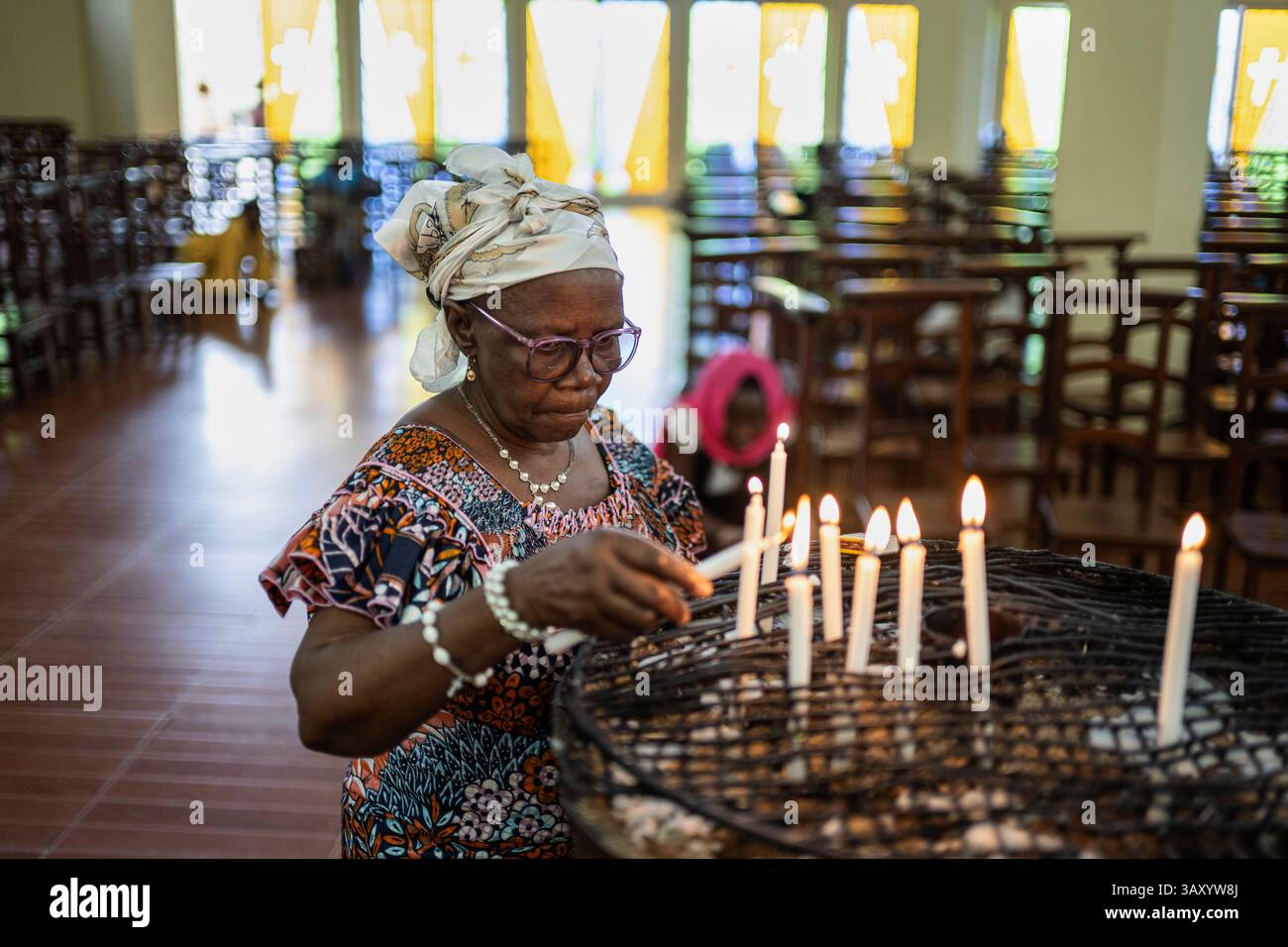 A woman lights candles in memory of Pope Francis during the morning ...