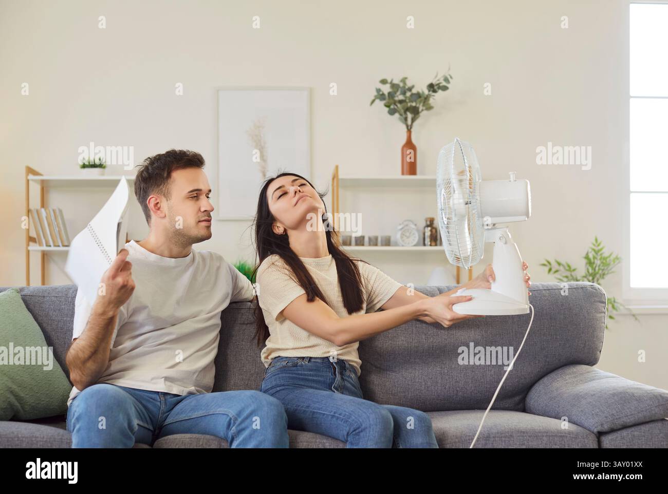 Family couple, woman, man enjoying freshness using electric ventilator ...