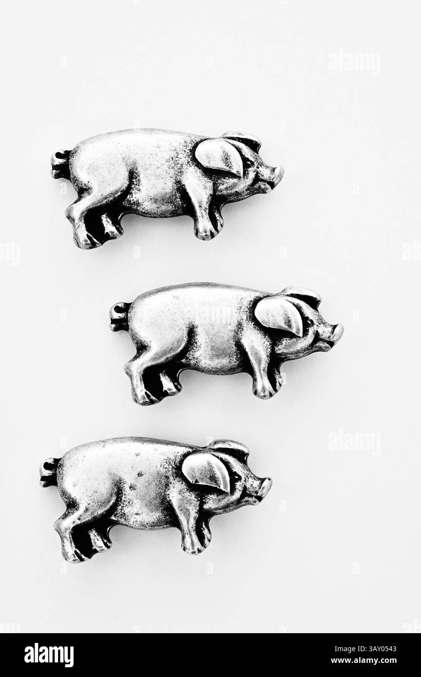 Three silver models of pigs lying above each other Stock Photo - Alamy