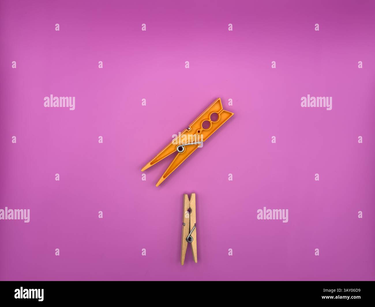 Modern orange plastic clothes peg versus old wooden brown clothes peg ...