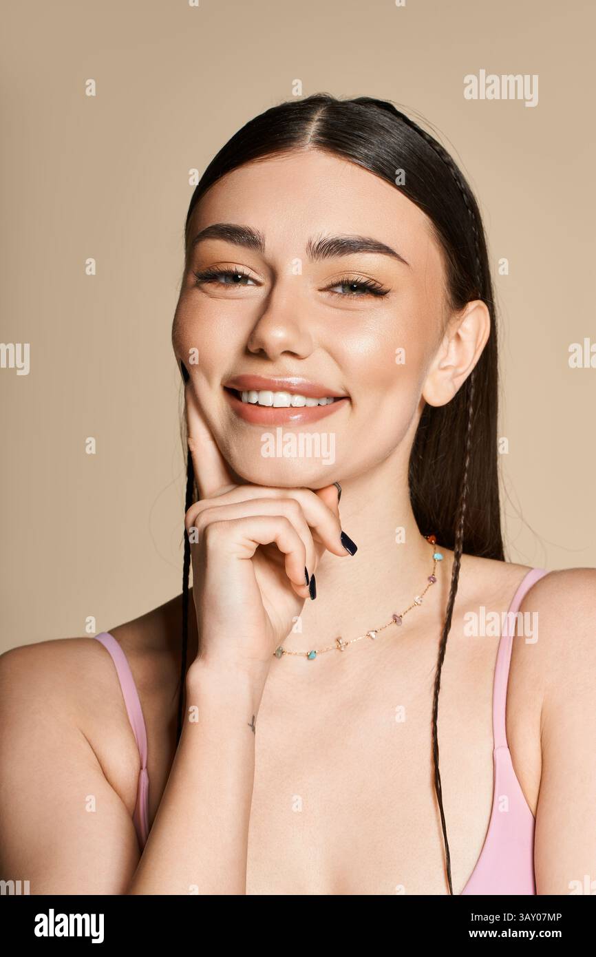 A young woman with a radiant smile showcases her sun-kissed skin while ...