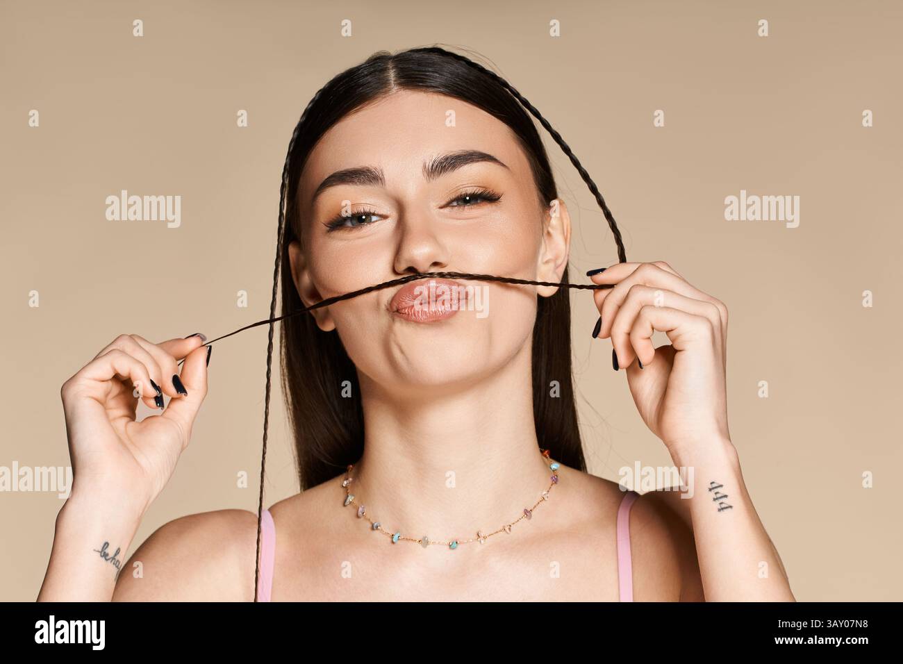 A young woman with a sun tan playfully poses, showcasing her carefree ...