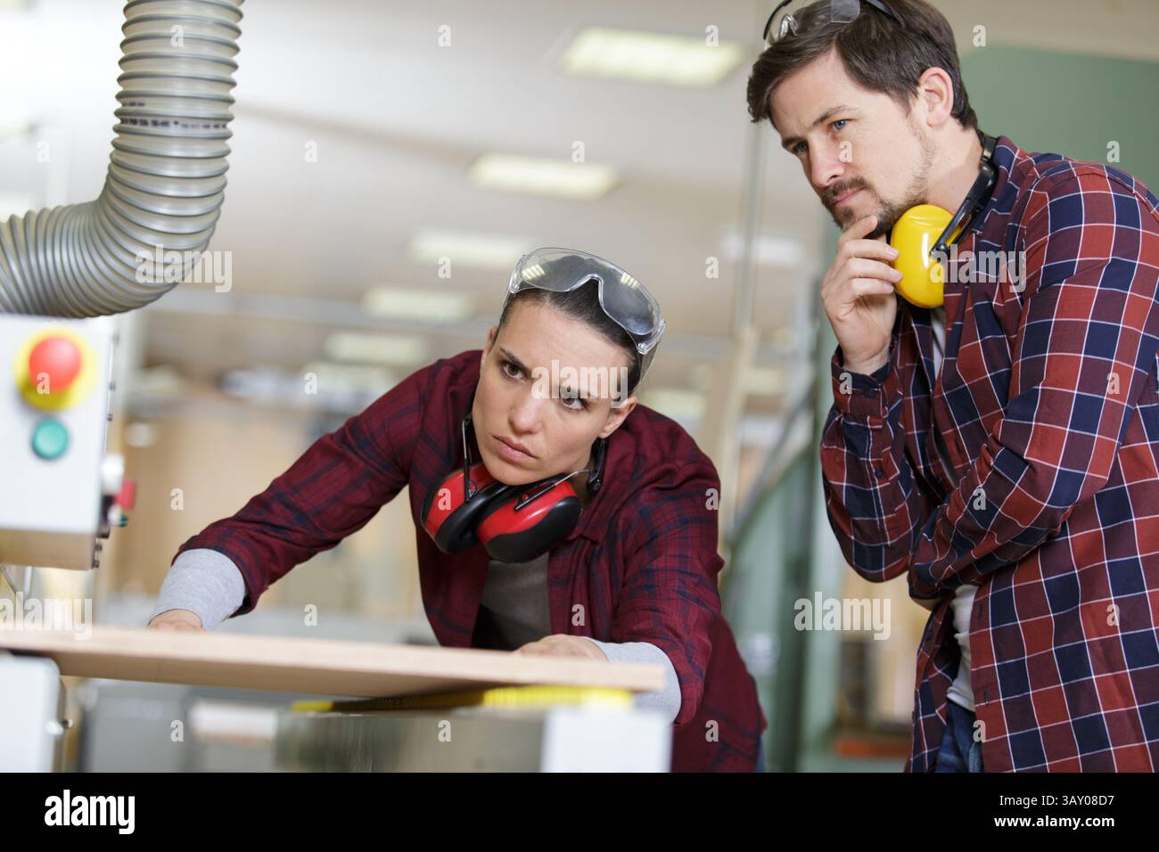 woman and man checking wood machine Stock Photo - Alamy