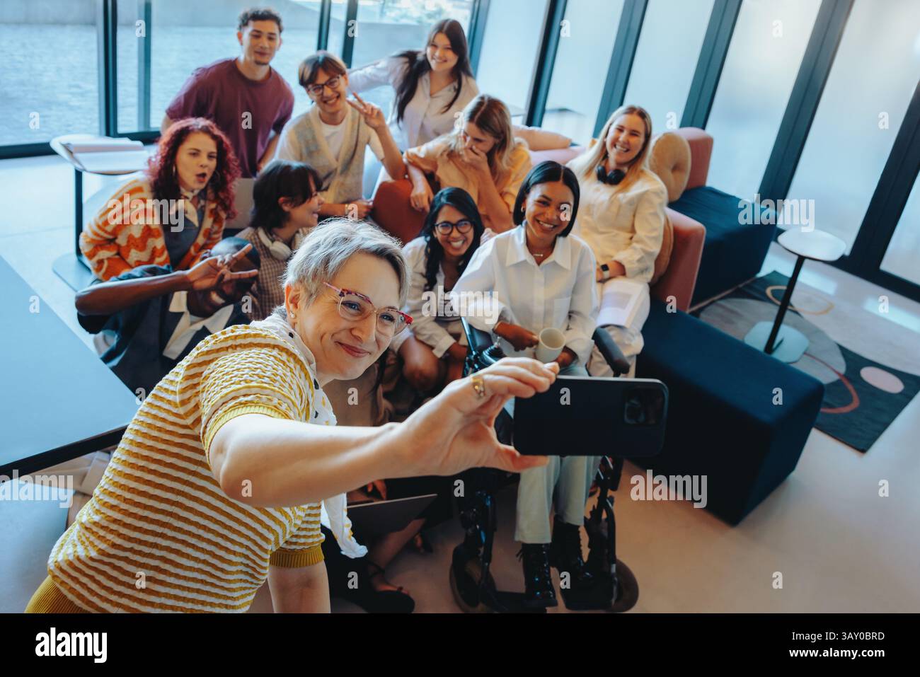 A group of university classmates posing together for a cheerful selfie ...