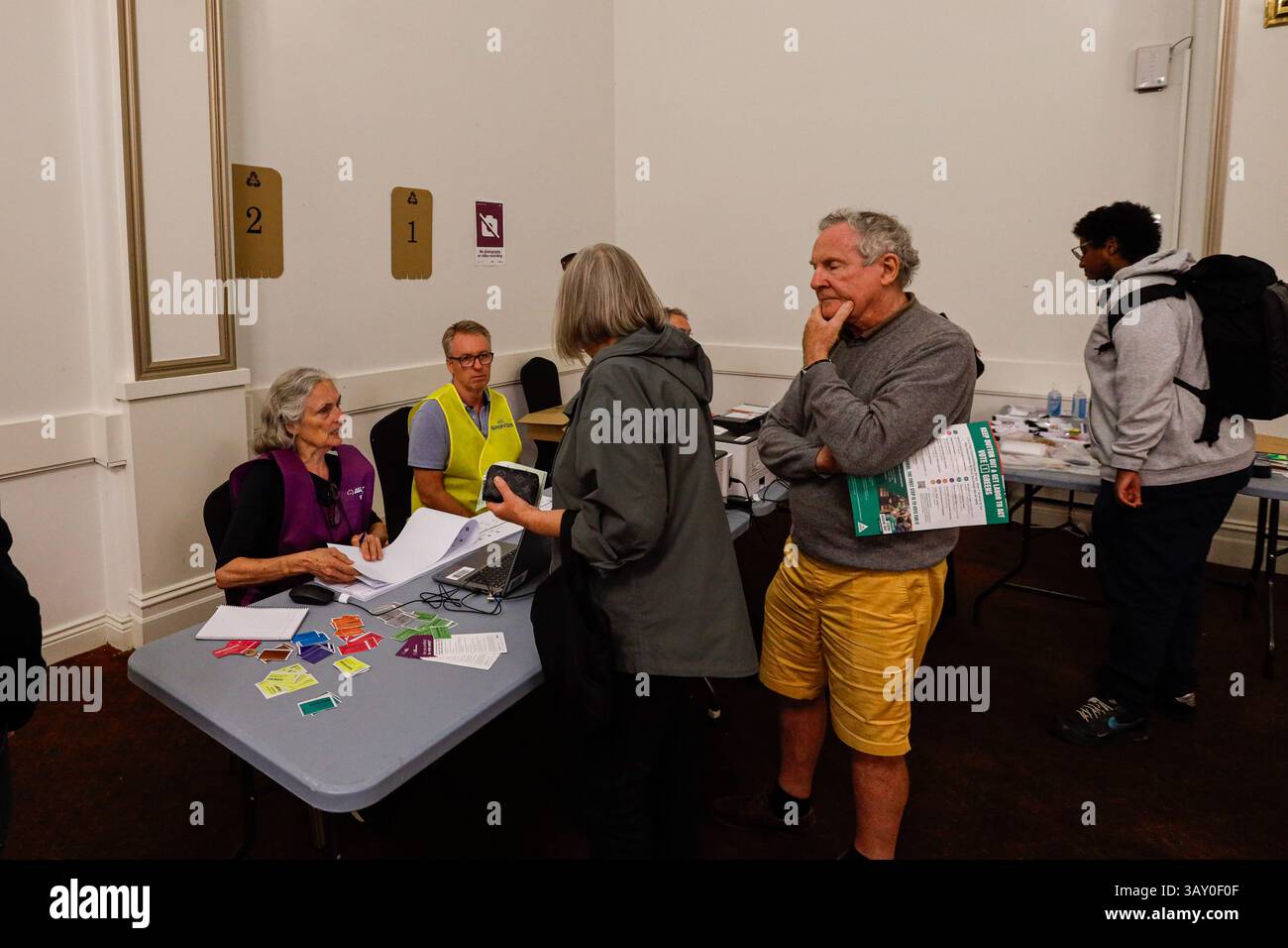 Voters register with Australian federal election (AEC) staff at a ...