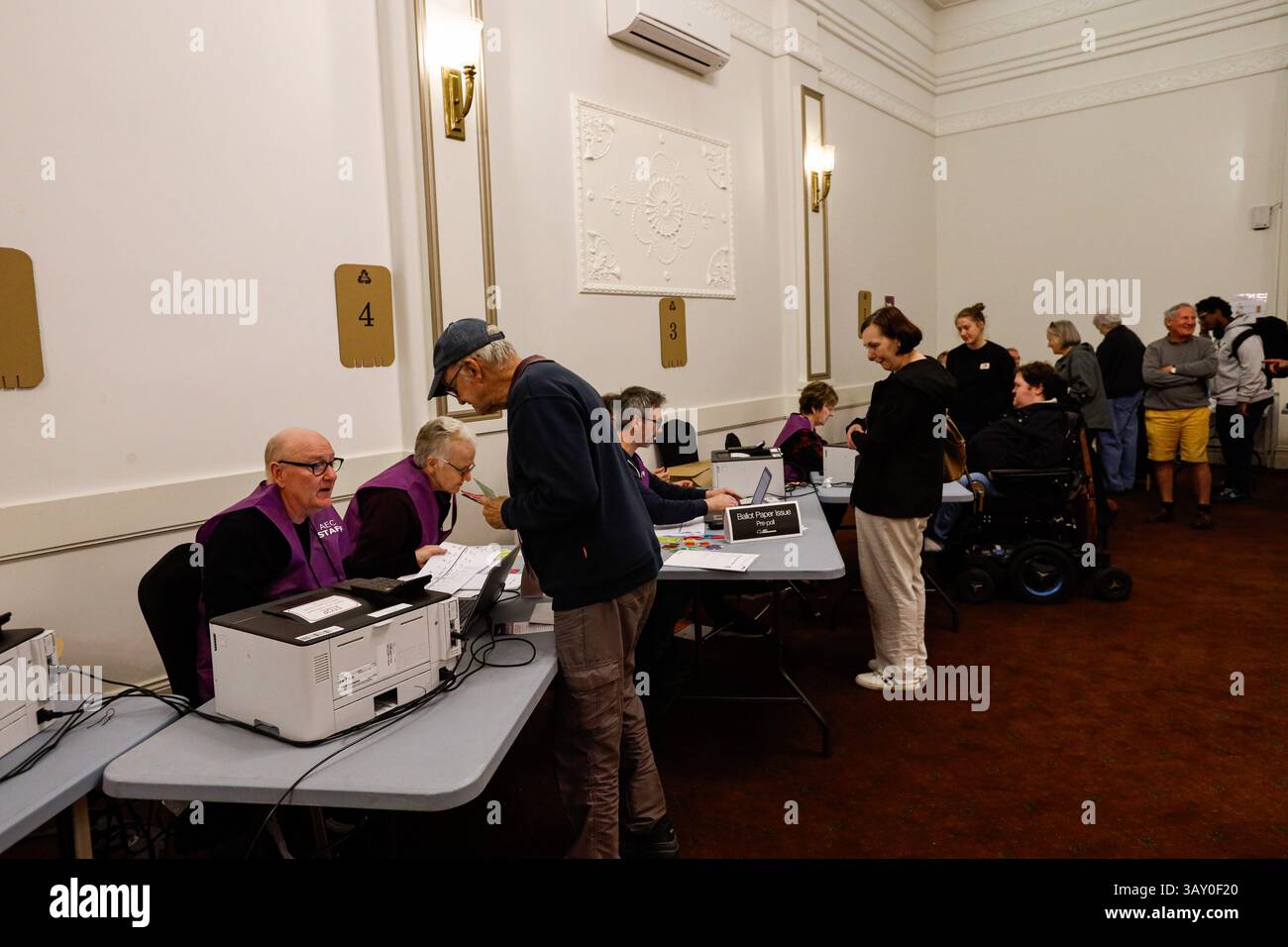 Voters register with Australian federal election (AEC) staff at a ...