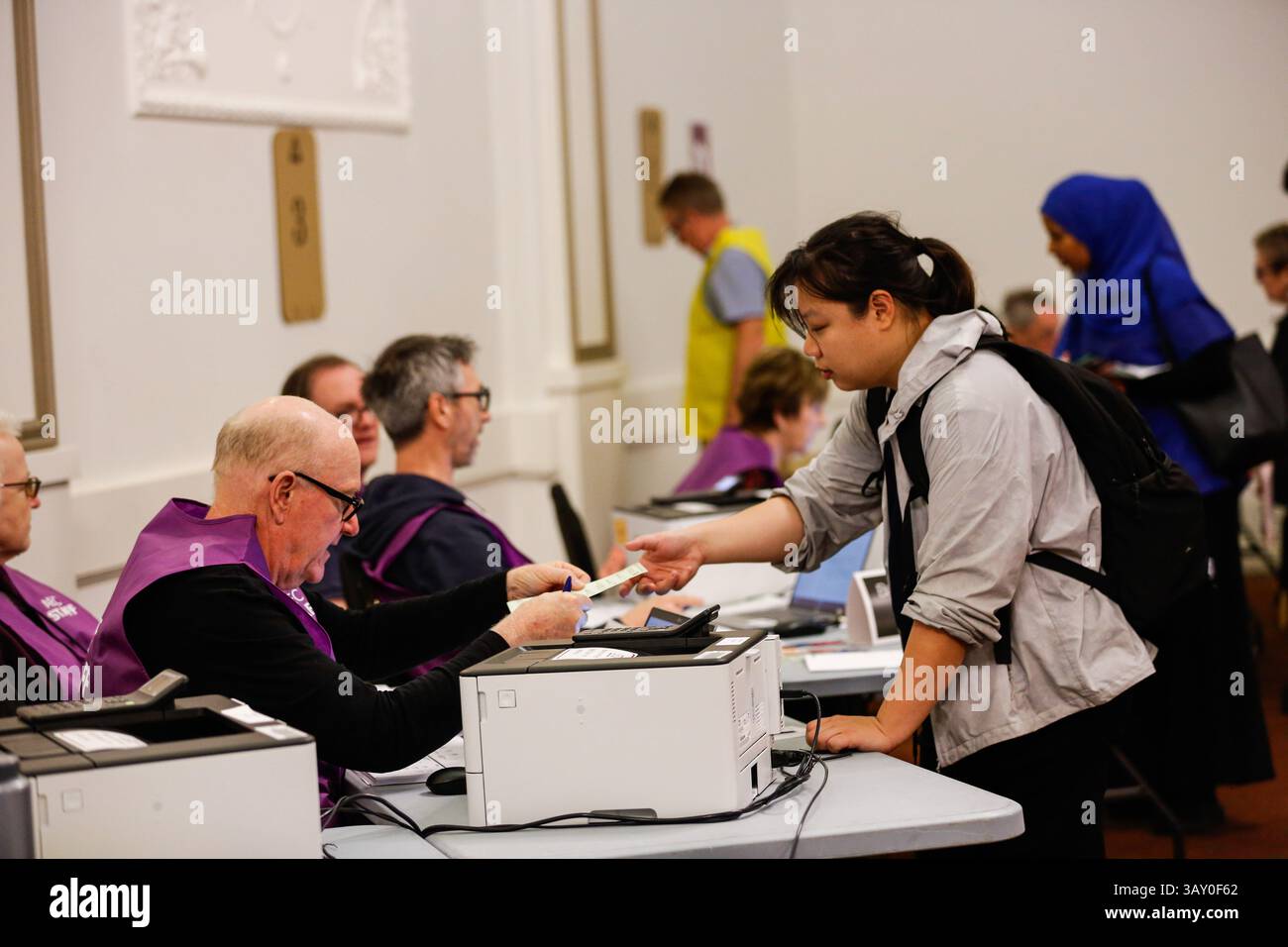 Voters register with Australian federal election (AEC) staff at a ...