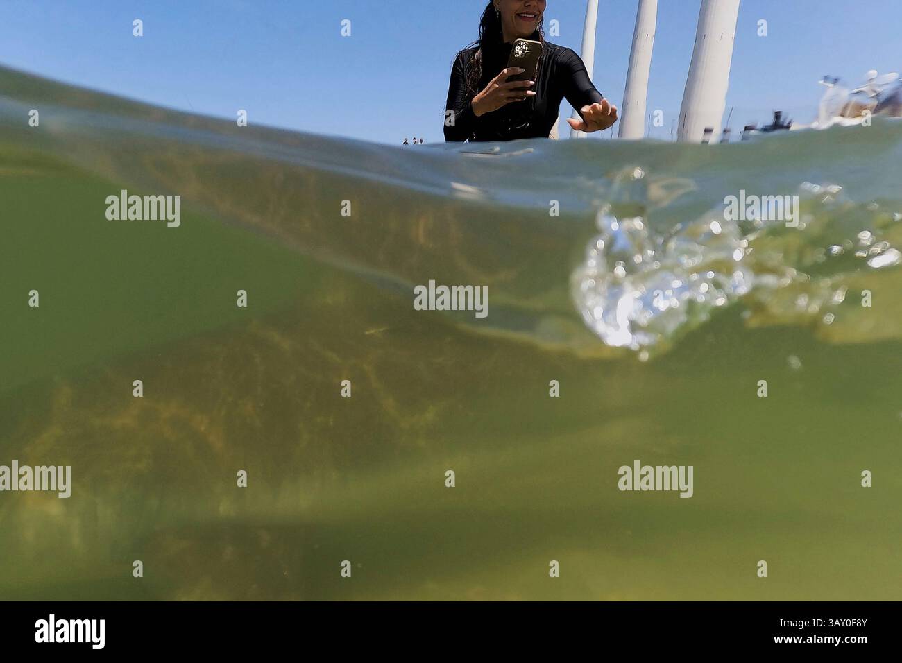 A woman reaches to a shark swimming in Mediterranean Sea in Hadera ...