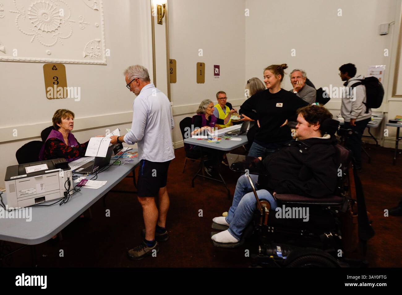 Voters register with Australian federal election (AEC) staff at a ...