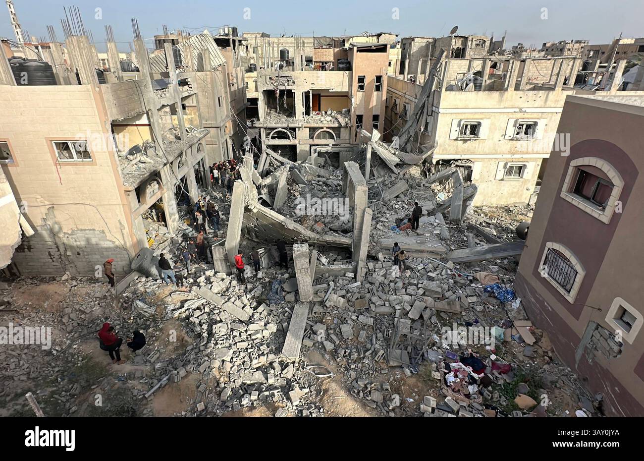 Palestinians inspect the area among the rubbles of destroyed buildings ...