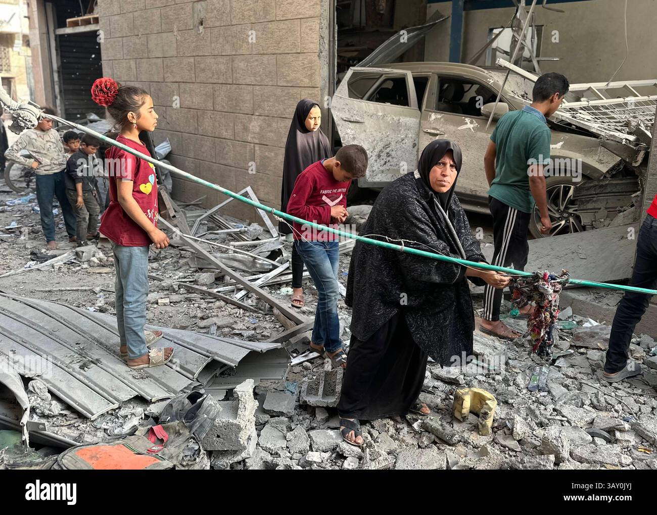 Palestinians inspect the area among the rubbles of destroyed buildings ...