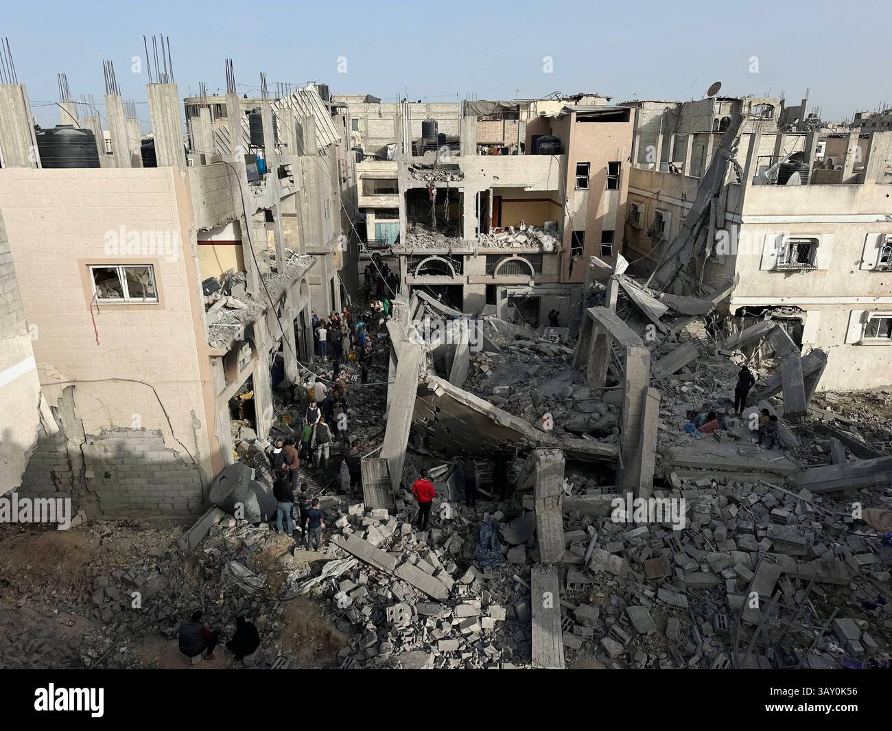 Palestinians inspect the area among the rubbles of destroyed buildings ...