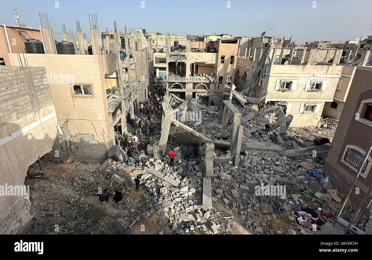 Palestinians inspect the area among the rubbles of destroyed buildings ...