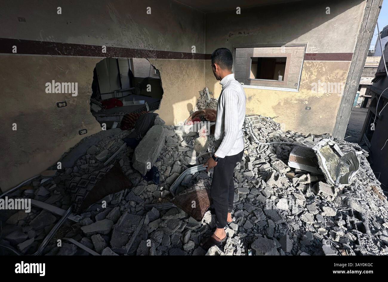 Palestinians inspect the area among the rubbles of destroyed buildings ...