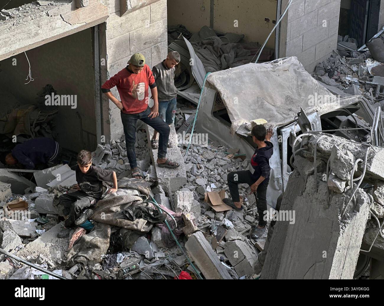 Palestinians inspect the area among the rubbles of destroyed buildings ...