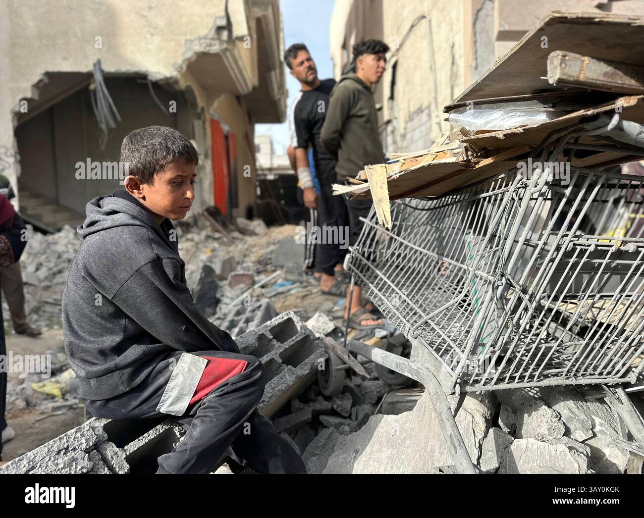 Palestinians inspect the area among the rubbles of destroyed buildings ...