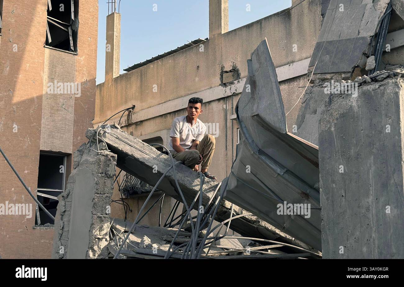 Palestinians inspect the area among the rubbles of destroyed buildings ...