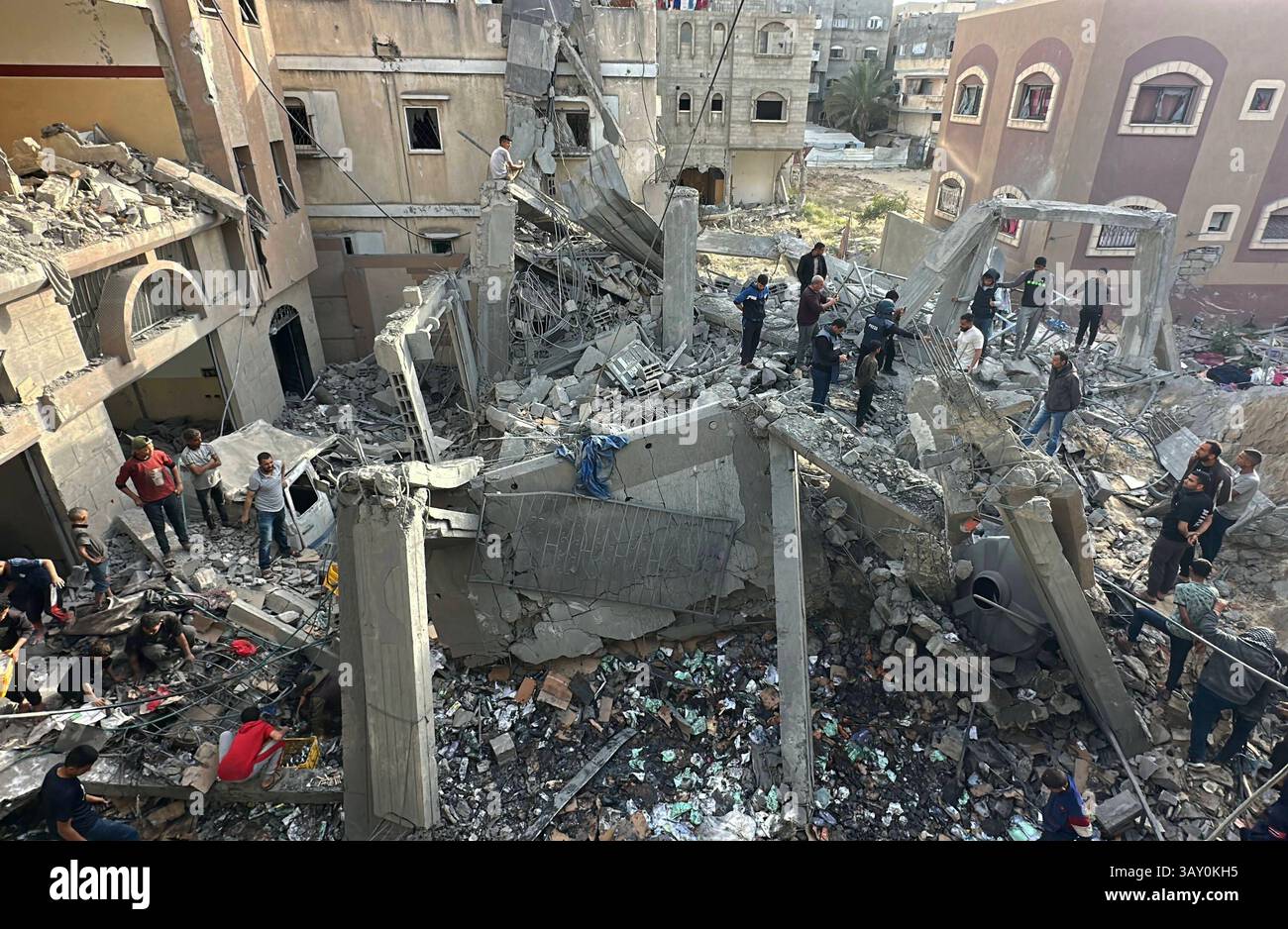 Palestinians inspect the area among the rubbles of destroyed buildings ...