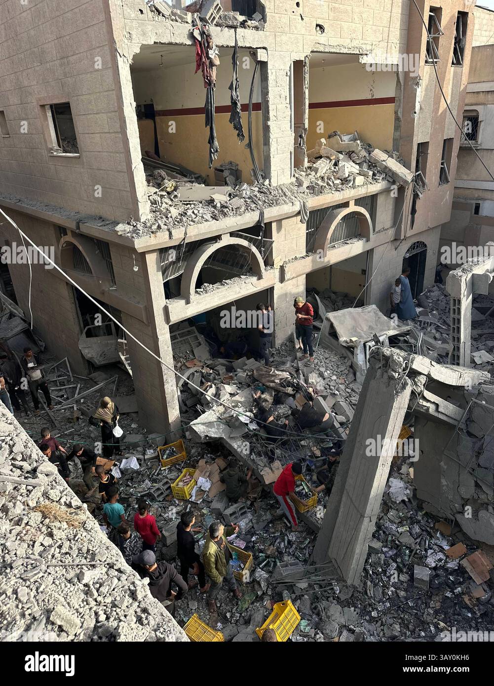 Palestinians inspect the area among the rubbles of destroyed buildings ...