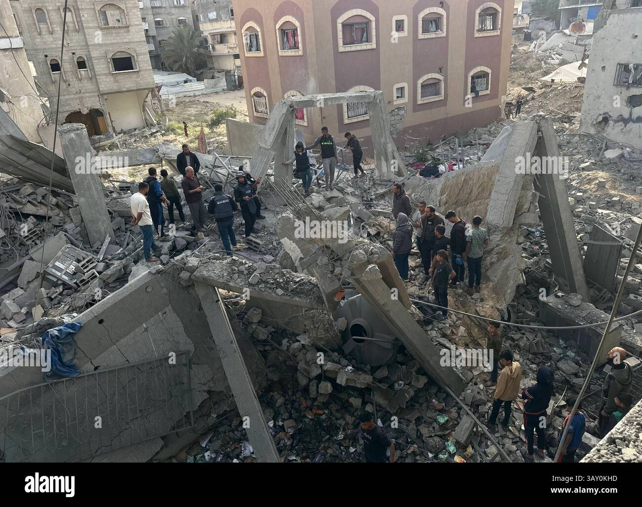 Palestinians inspect the area among the rubbles of destroyed buildings ...