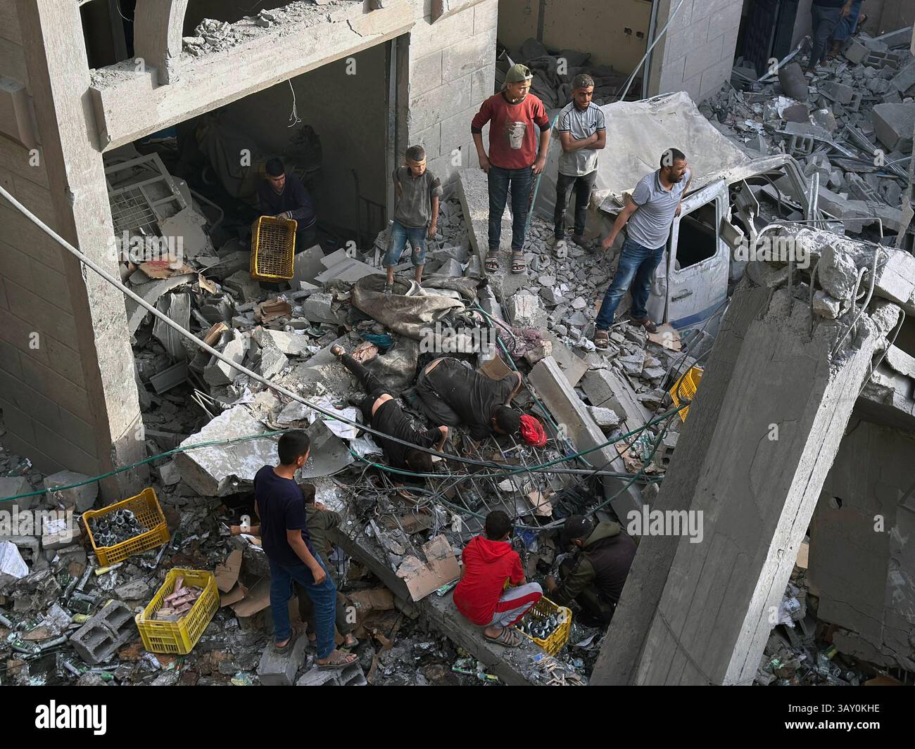 Palestinians inspect the area among the rubbles of destroyed buildings ...