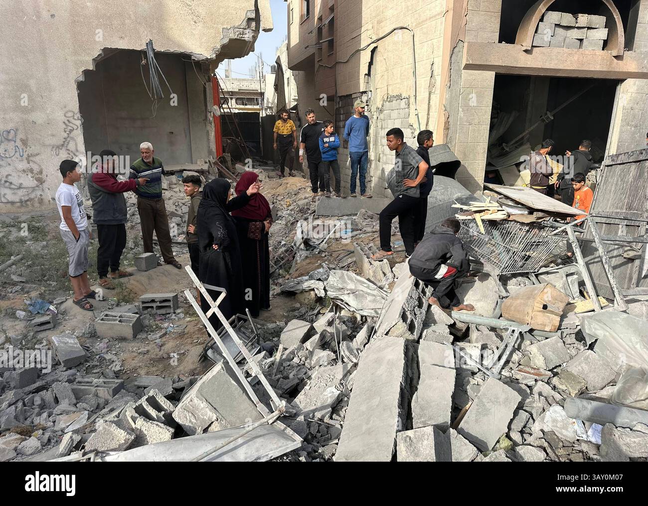 Palestinians inspect the area among the rubbles of destroyed buildings ...