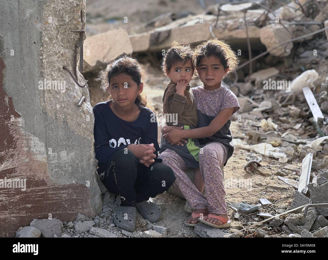Palestinians inspect the area among the rubbles of destroyed buildings ...