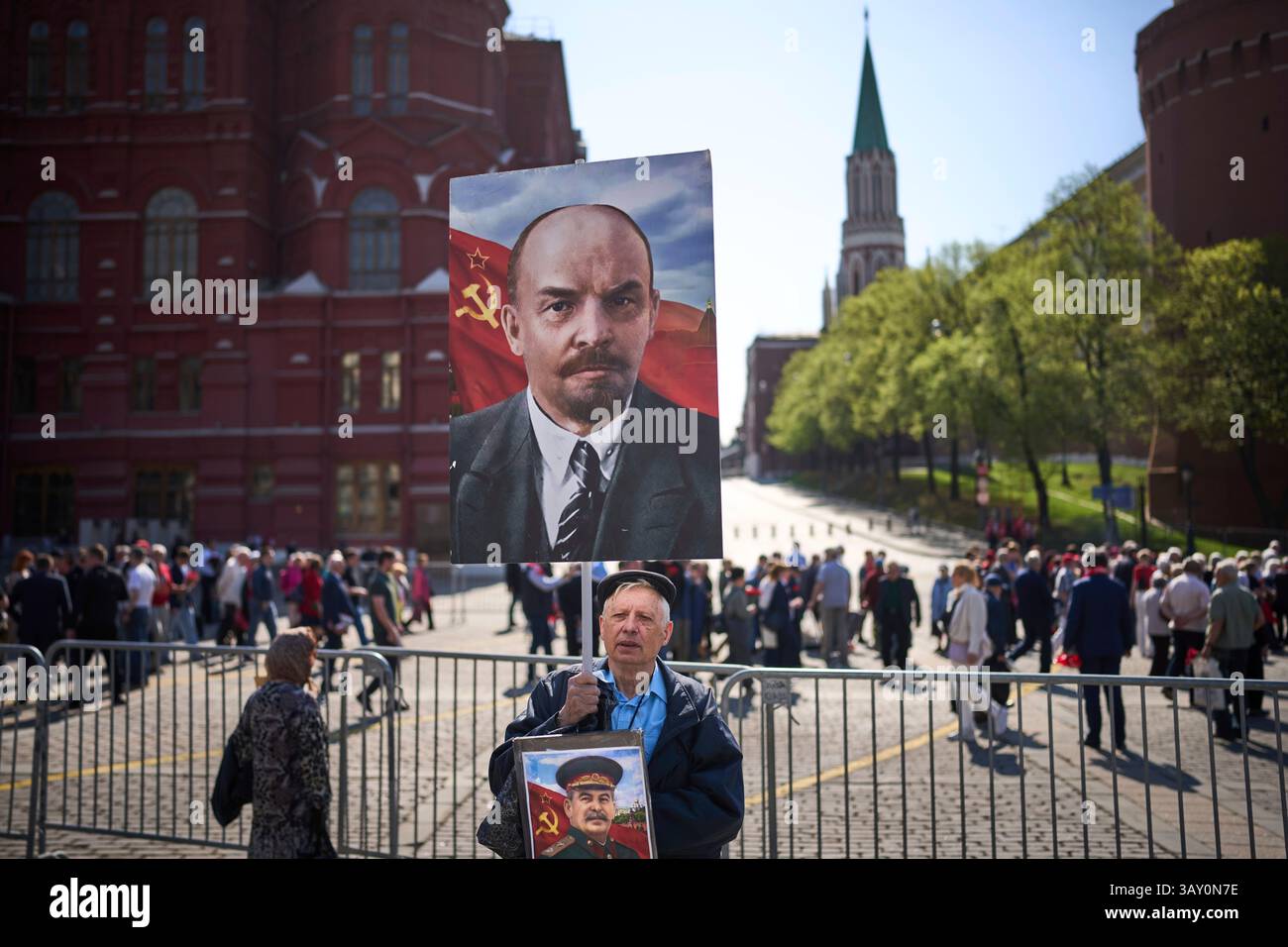 A Russian communists supporter stands holding a portrait of Soviet ...