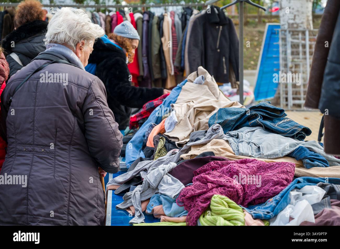 People looking at a pile of second hand clothes in a flea market Stock ...