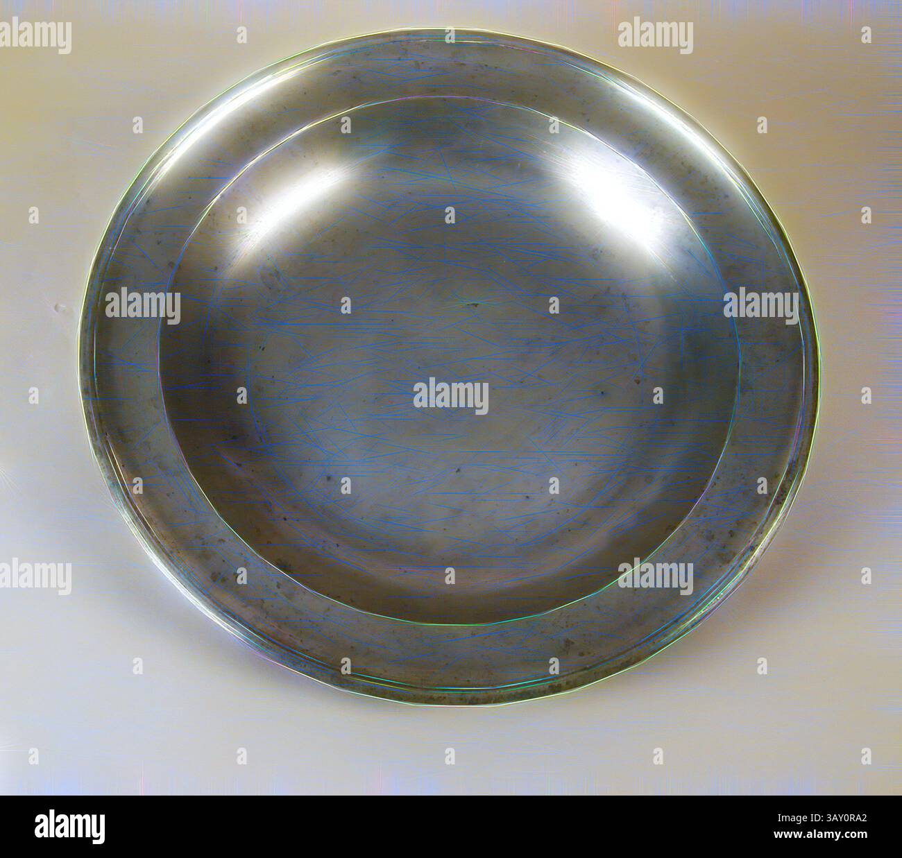 A round, polished metal plate with a slightly elevated rim, showcasing ...