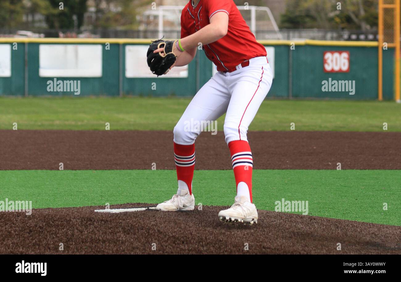 A high school Baseball pitcher starting his wind up while piching ...