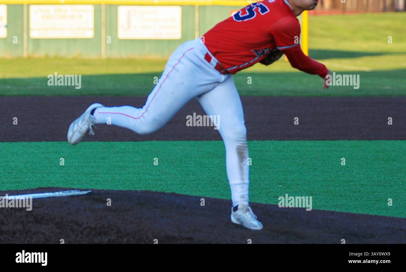 A dedicated high school athlete pitches on a vibrant baseball diamond ...
