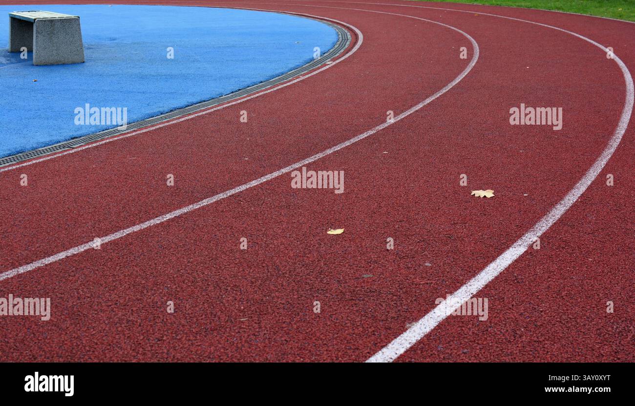 Red running track with blue sports field in left side Stock Photo - Alamy