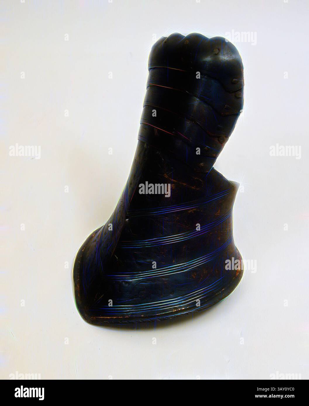 A sculpted object resembling a hand raised in a fist, featuring ridges ...