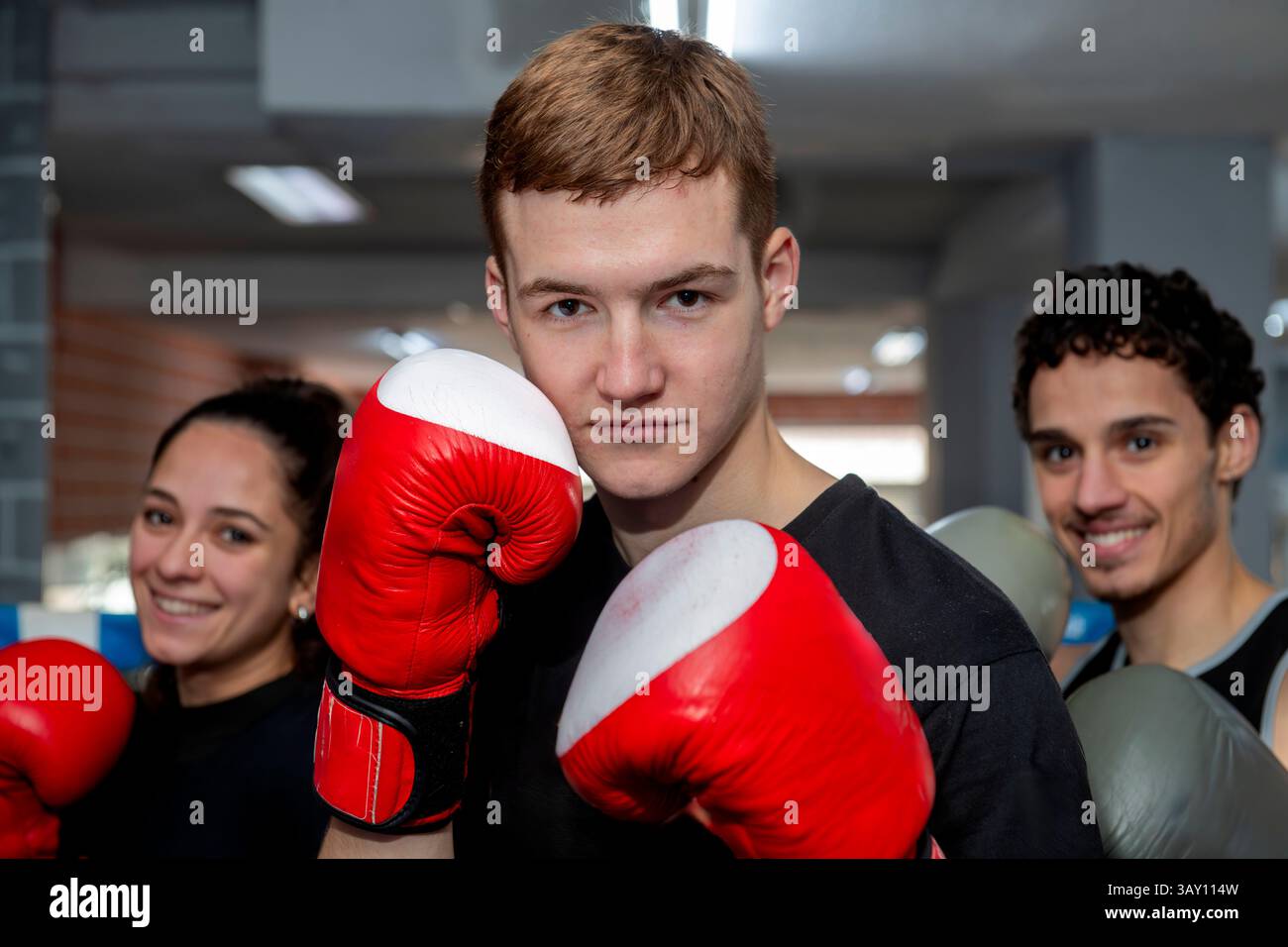 Group of young boxers wearing boxing gloves posing in a boxing ring ...