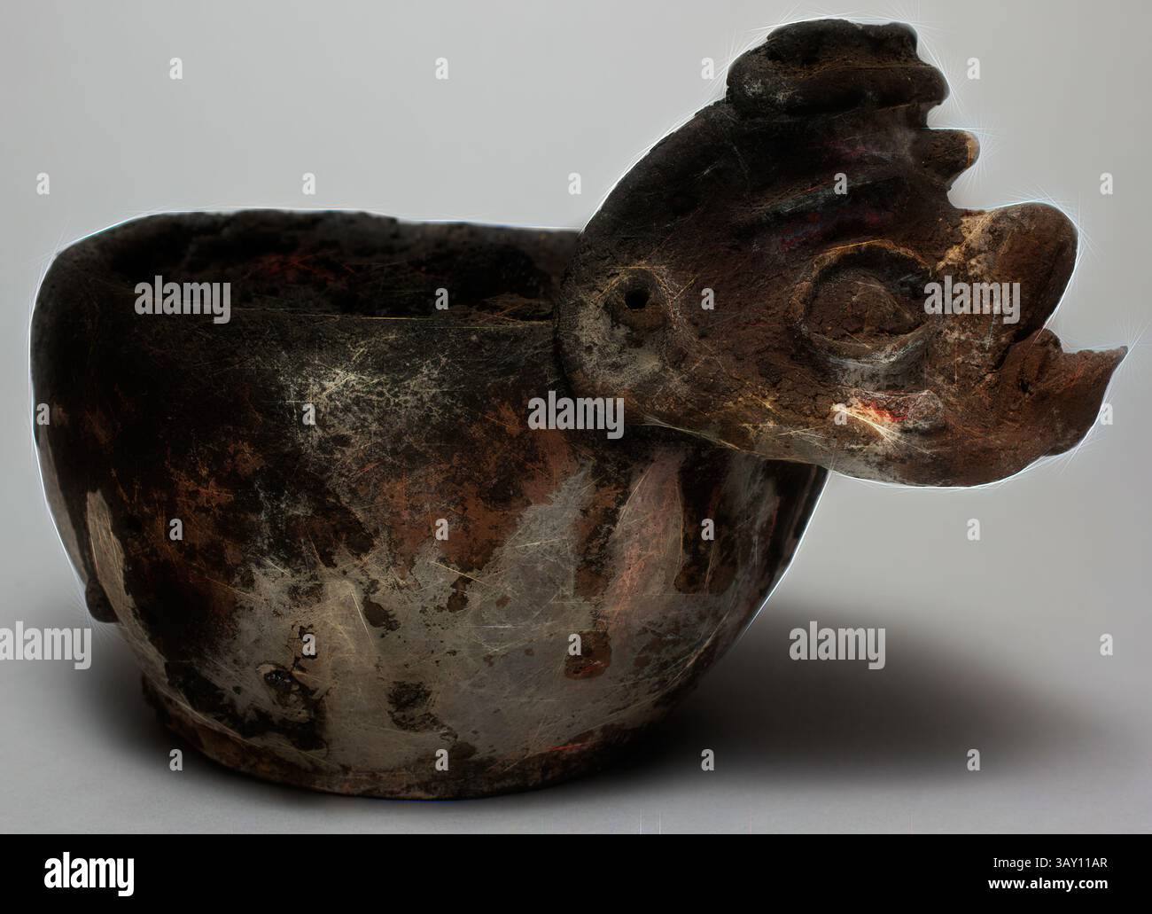 An intricately designed vessel featuring a stylized animal head ...