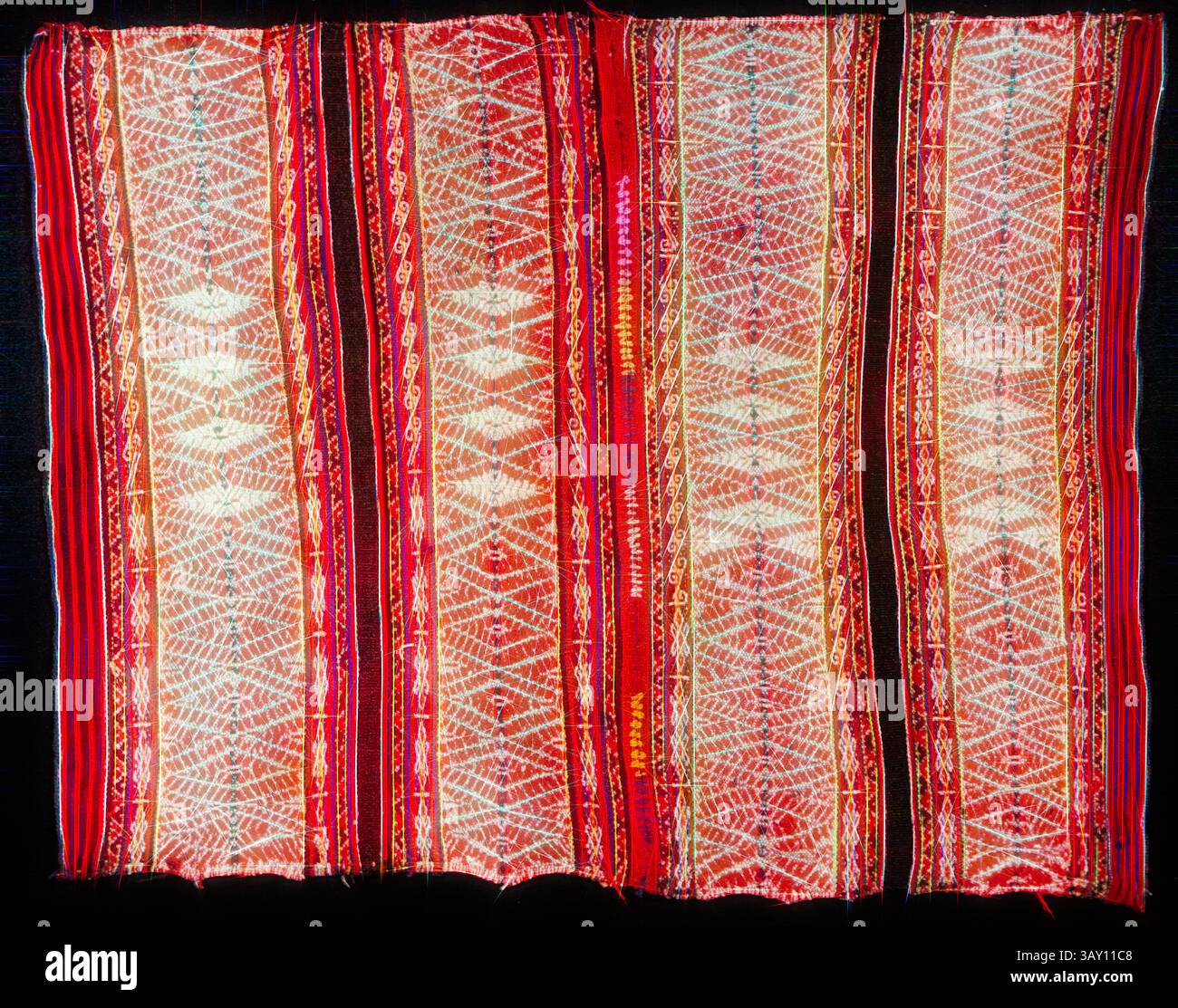 A vibrant textile featuring intricate patterns and bold reds ...