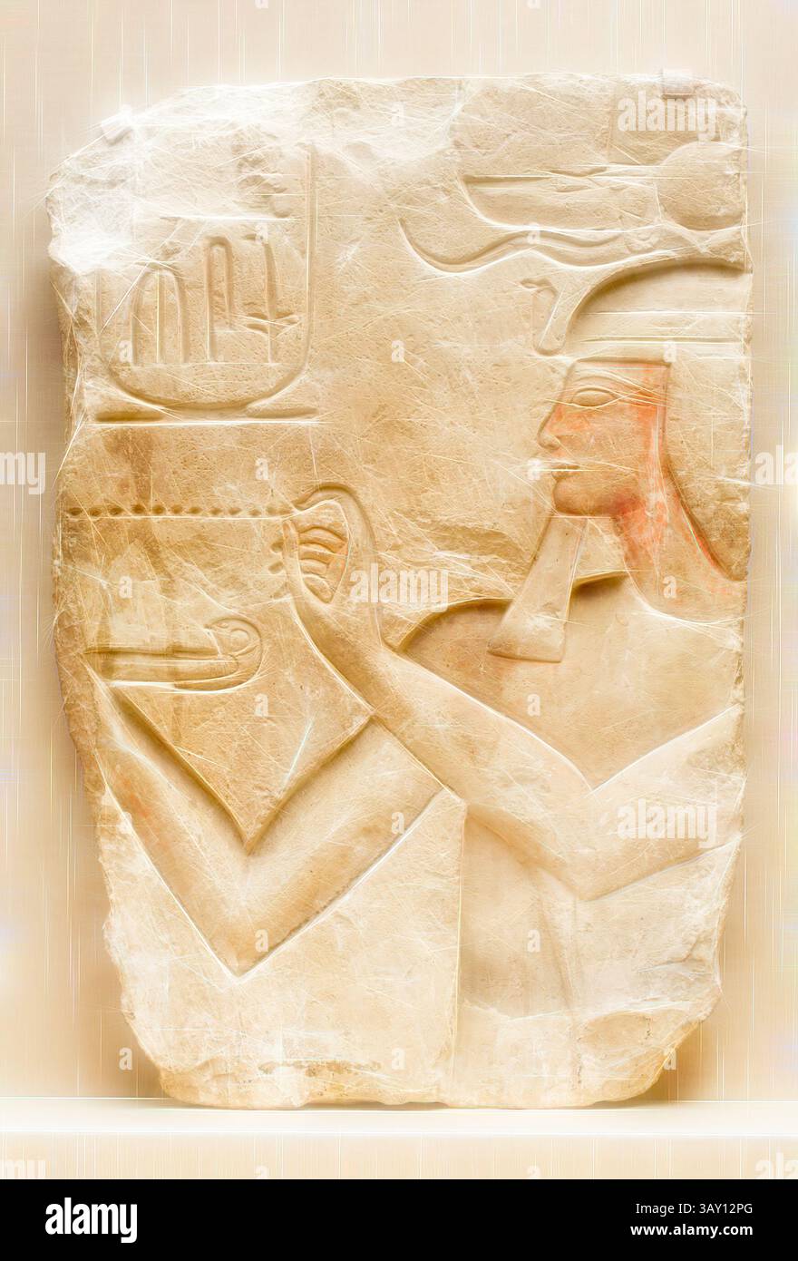 An ancient relief depicting a figure with a headdress, holding an item ...