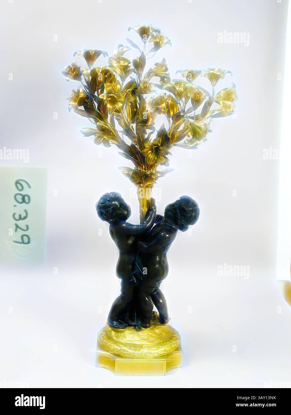 A decorative piece featuring two cherubic figures entwined around a ...