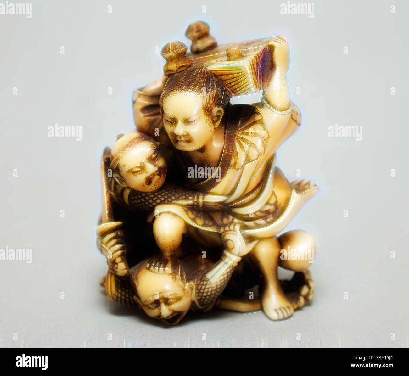 A detailed carving depicts a dynamic scene with three figures, two men ...