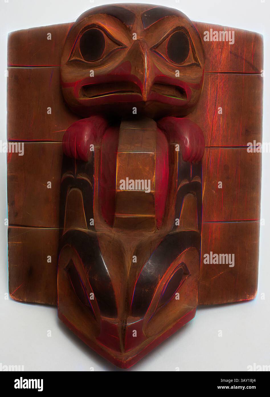 This intricately carved totem features a stylized eagle perched above a ...