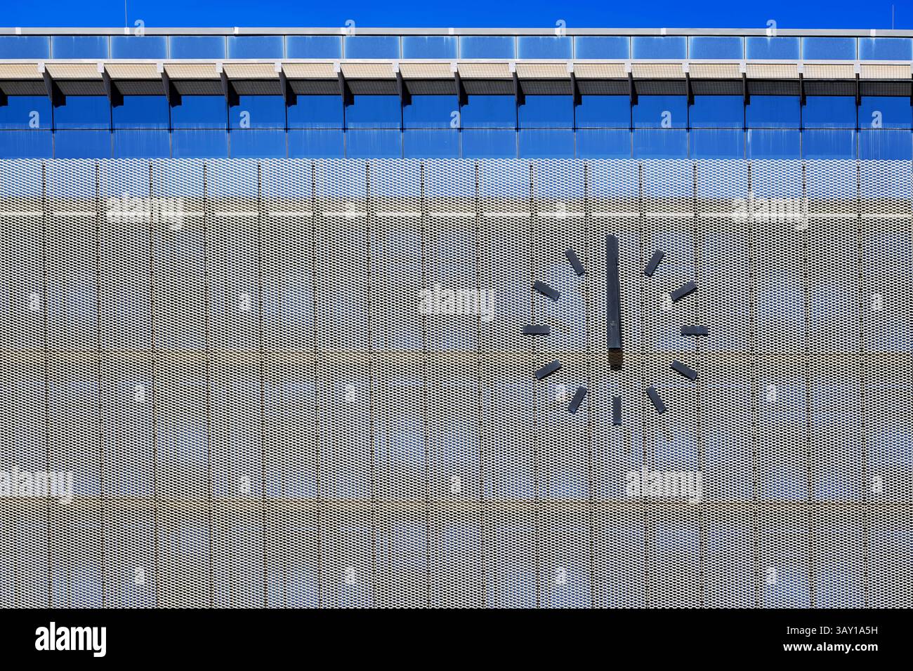 Minimalist wall clock with black dial and hands on the facade of a ...