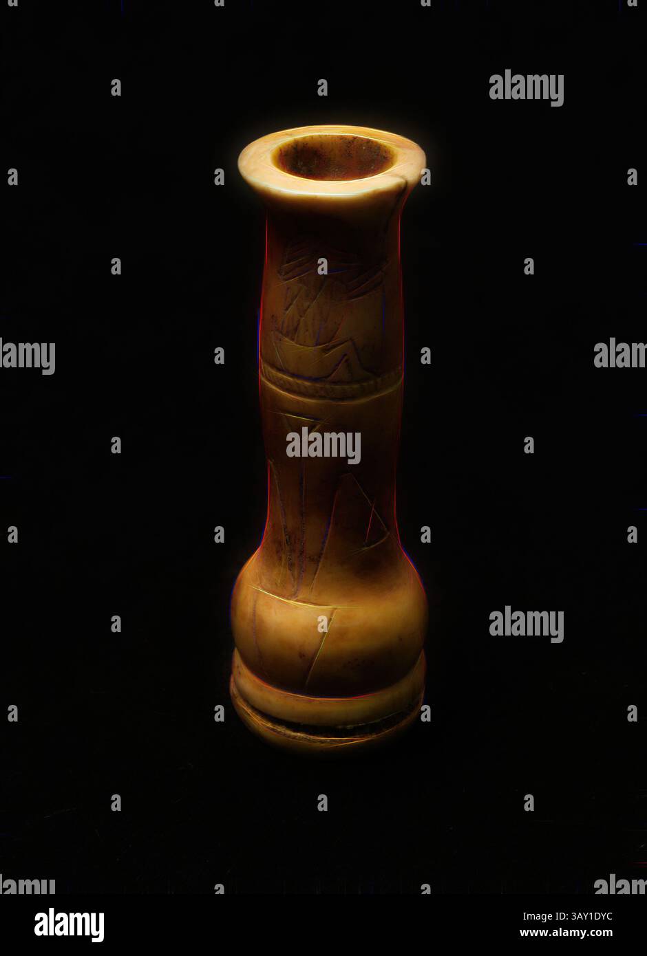 A tall, slender vessel with intricate carvings and a wide opening ...