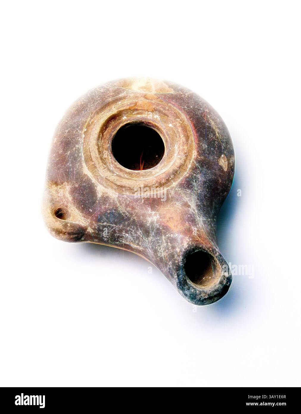 An ancient oil lamp with a rounded body and a single spout, featuring a ...
