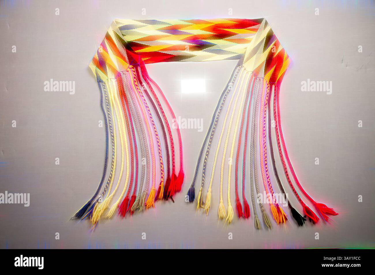A vibrant, intricately woven scarf features a diamond pattern with bold ...