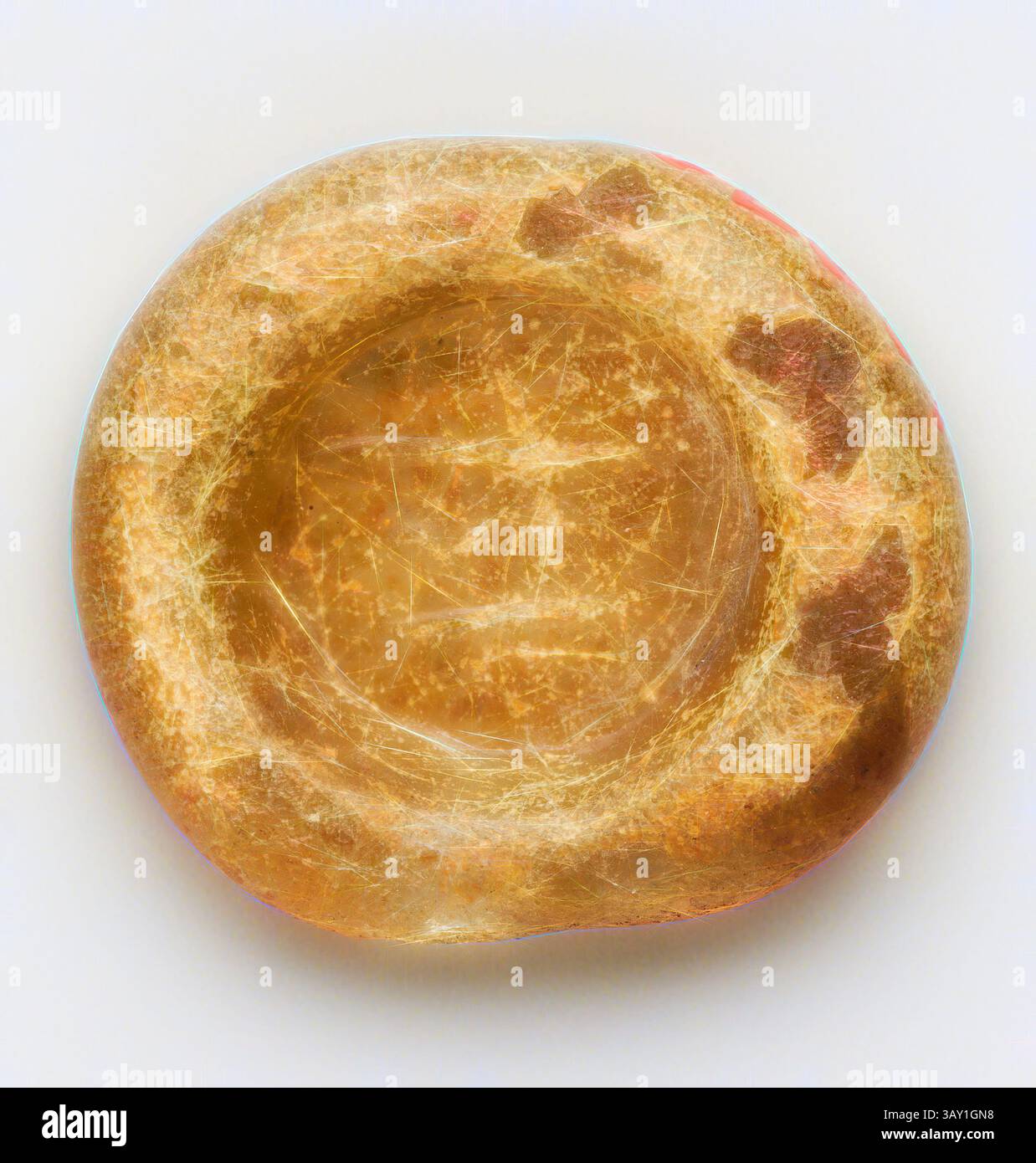 A smooth, oval-shaped object with a textured surface, showcasing a warm ...