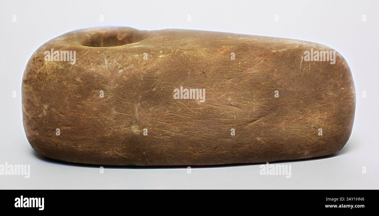 A smooth, elongated stone sculpture with a rounded indentation on one ...