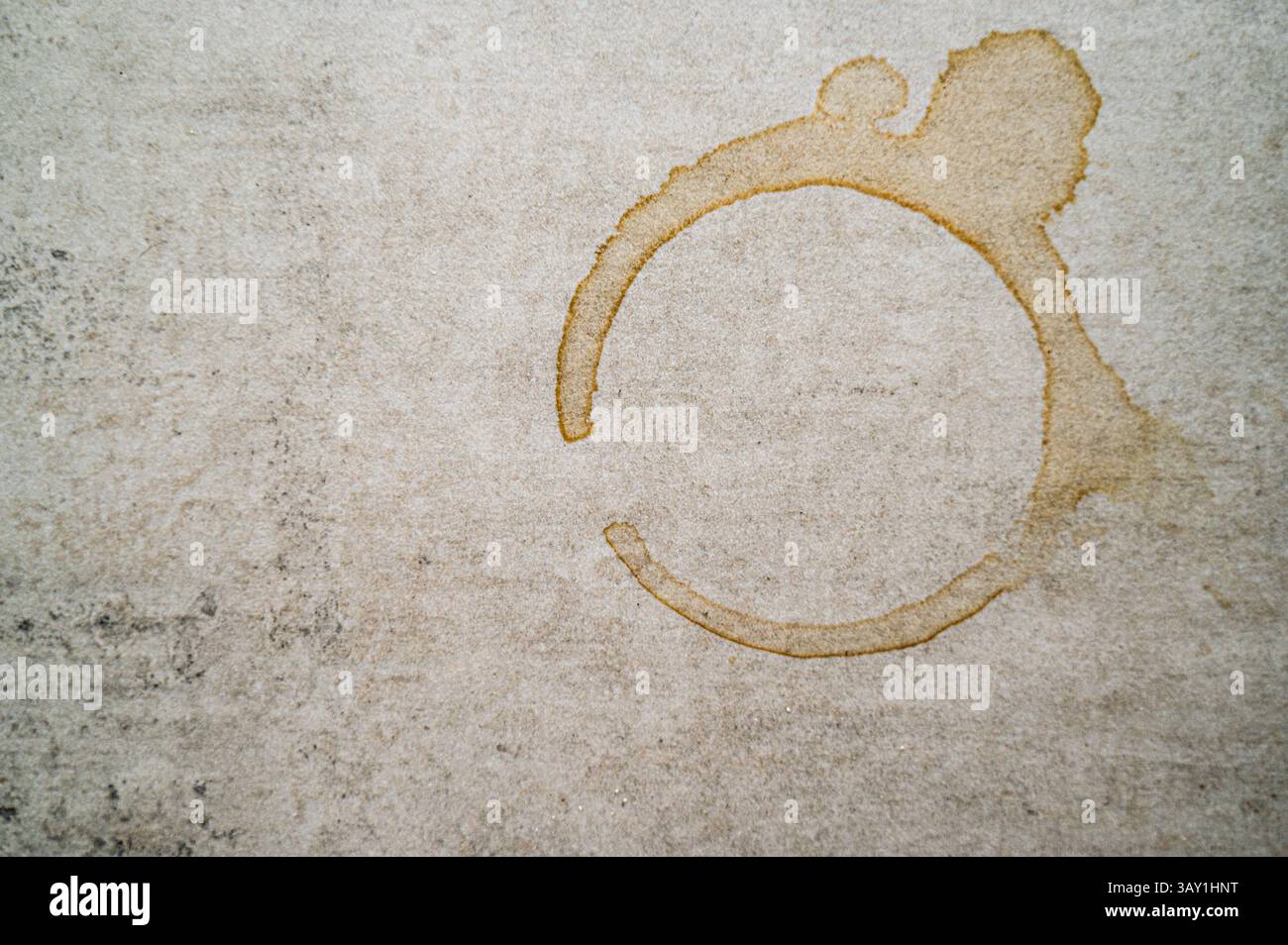 A closeup view of a coffee ring stain found on textured concrete, which ...