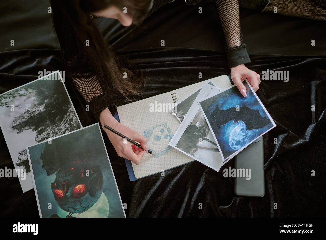 High angle shot of unrecognizable goth teenager lying on bed with black ...