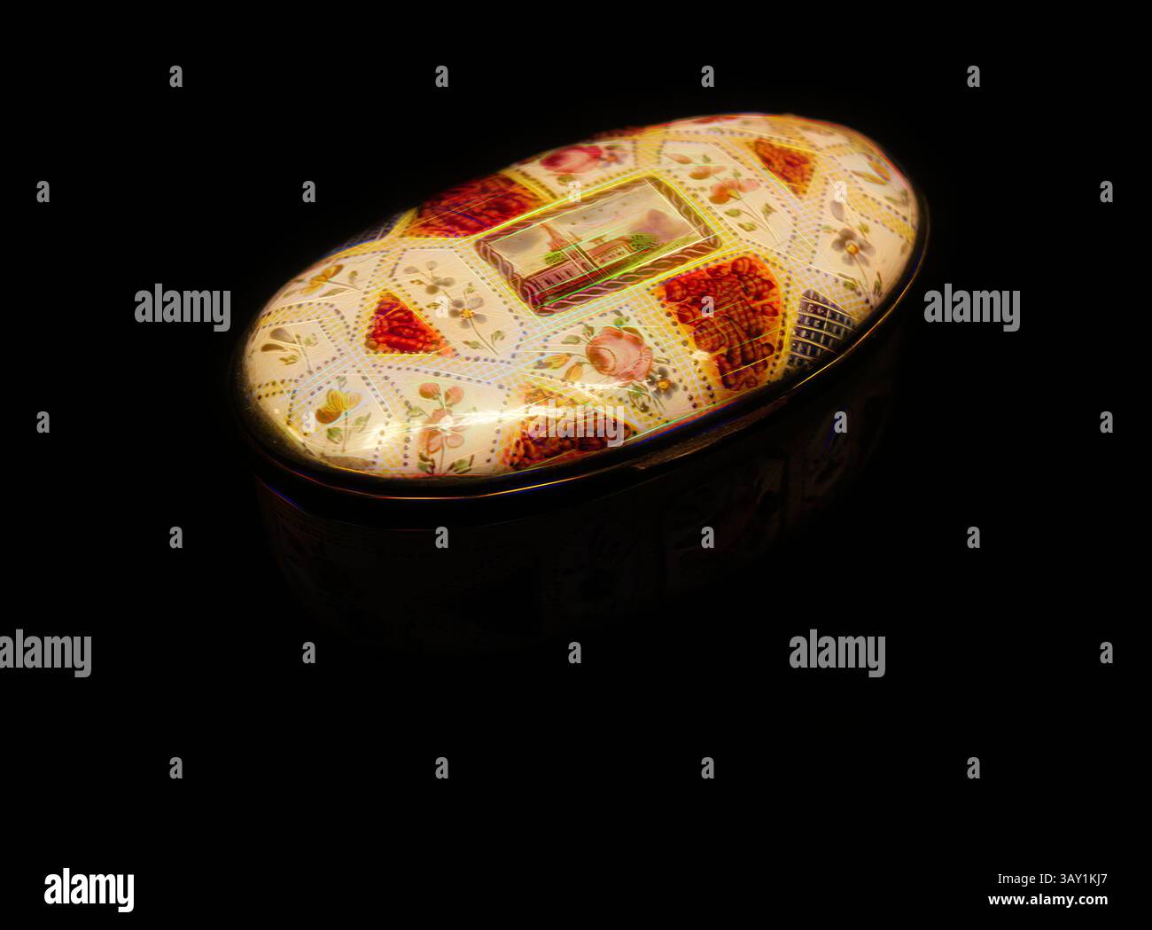An intricately designed oval trinket box featuring a detailed floral ...